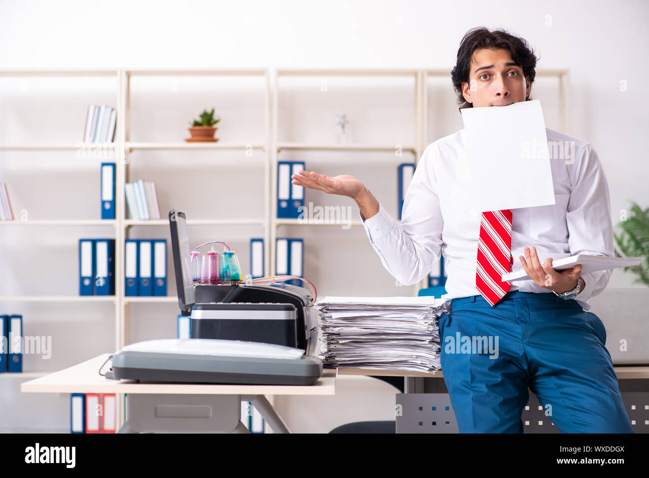 Young employee making copies at copying machine Stock Photo - Alamy