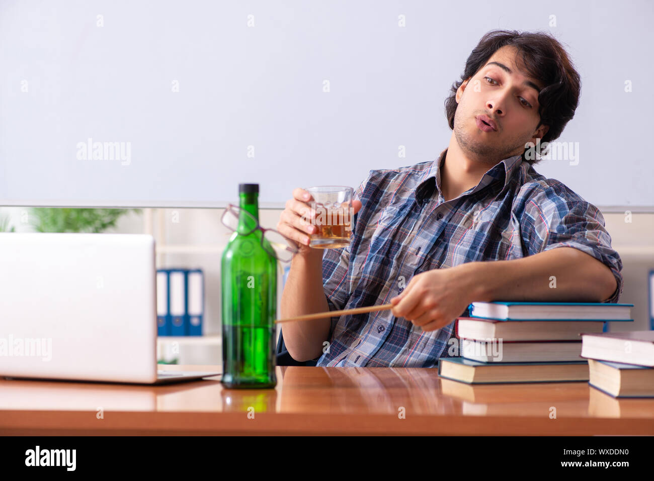 Male teacher drinking in the classroom Stock Photo - Alamy