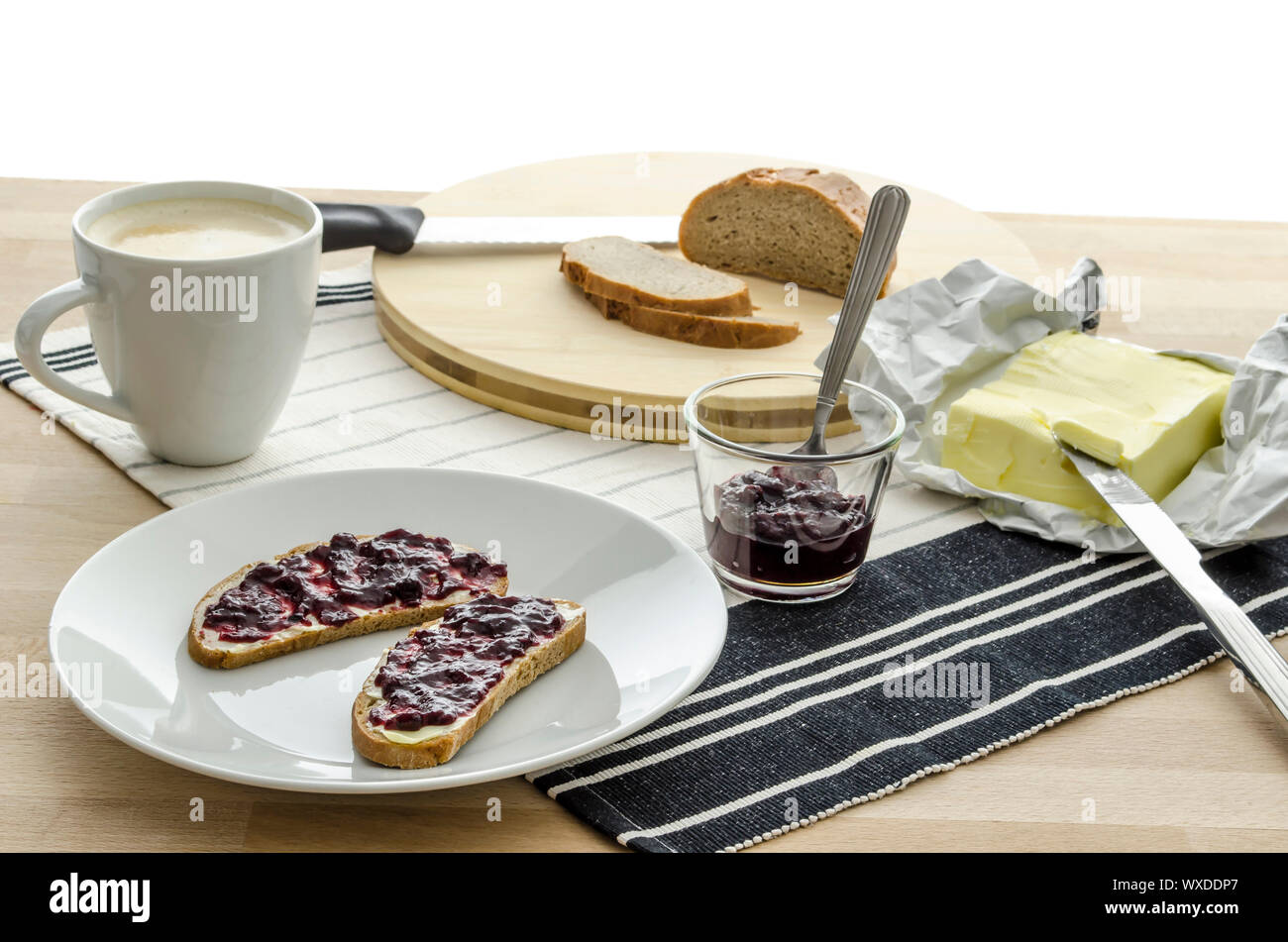 Table ready for breakfast with coffee, bread, jam and butter Stock ...