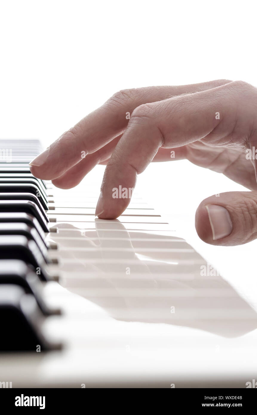 Isolated hand of pianist touching a key of electric piano with one ...