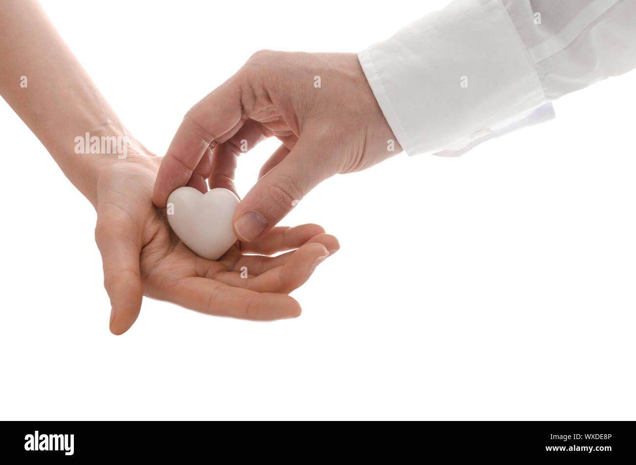 Male hand giving a heart to a woman. Isolated over white background ...