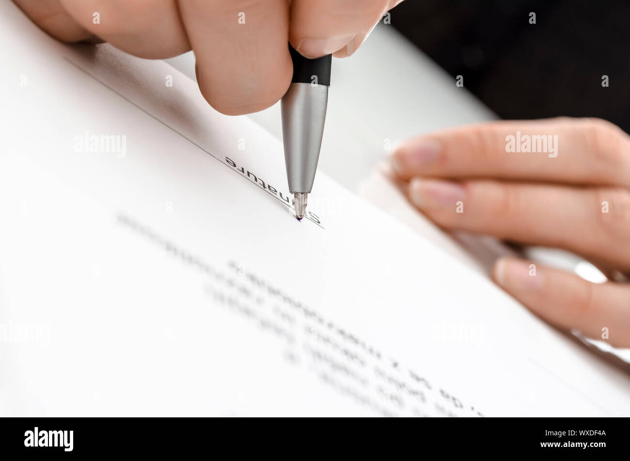 Detail of a female hand signing a contract above signature line Stock ...