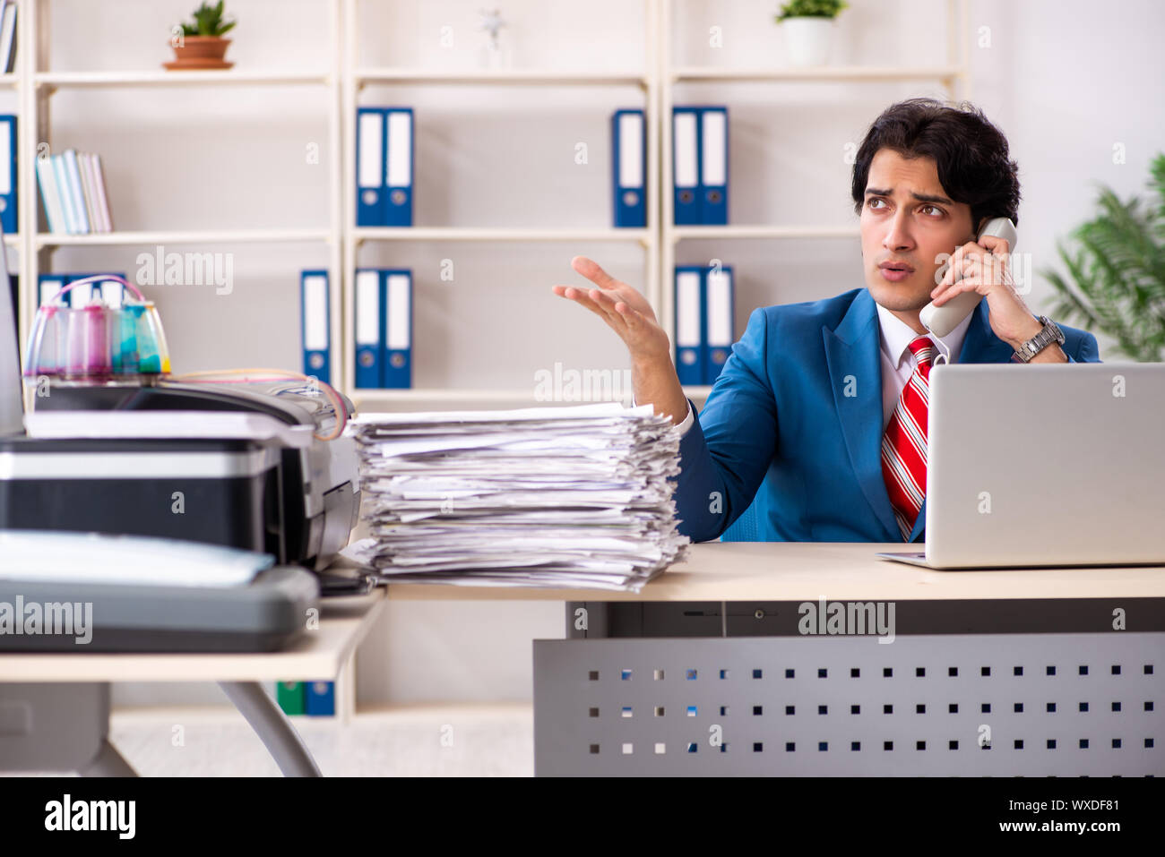 Young employee making copies at copying machine Stock Photo - Alamy