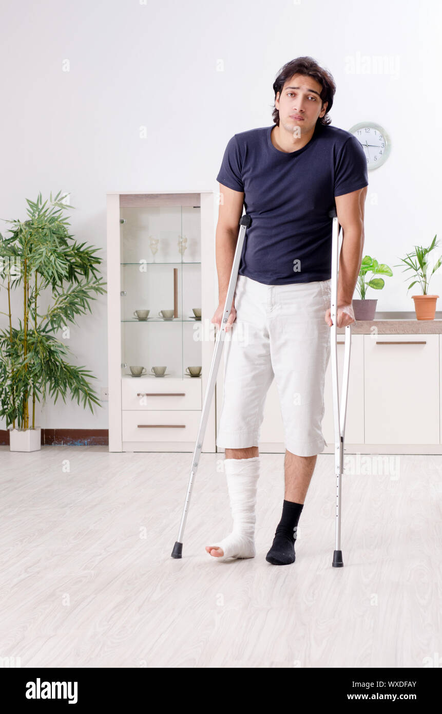 Leg injured young man suffering at home Stock Photo - Alamy