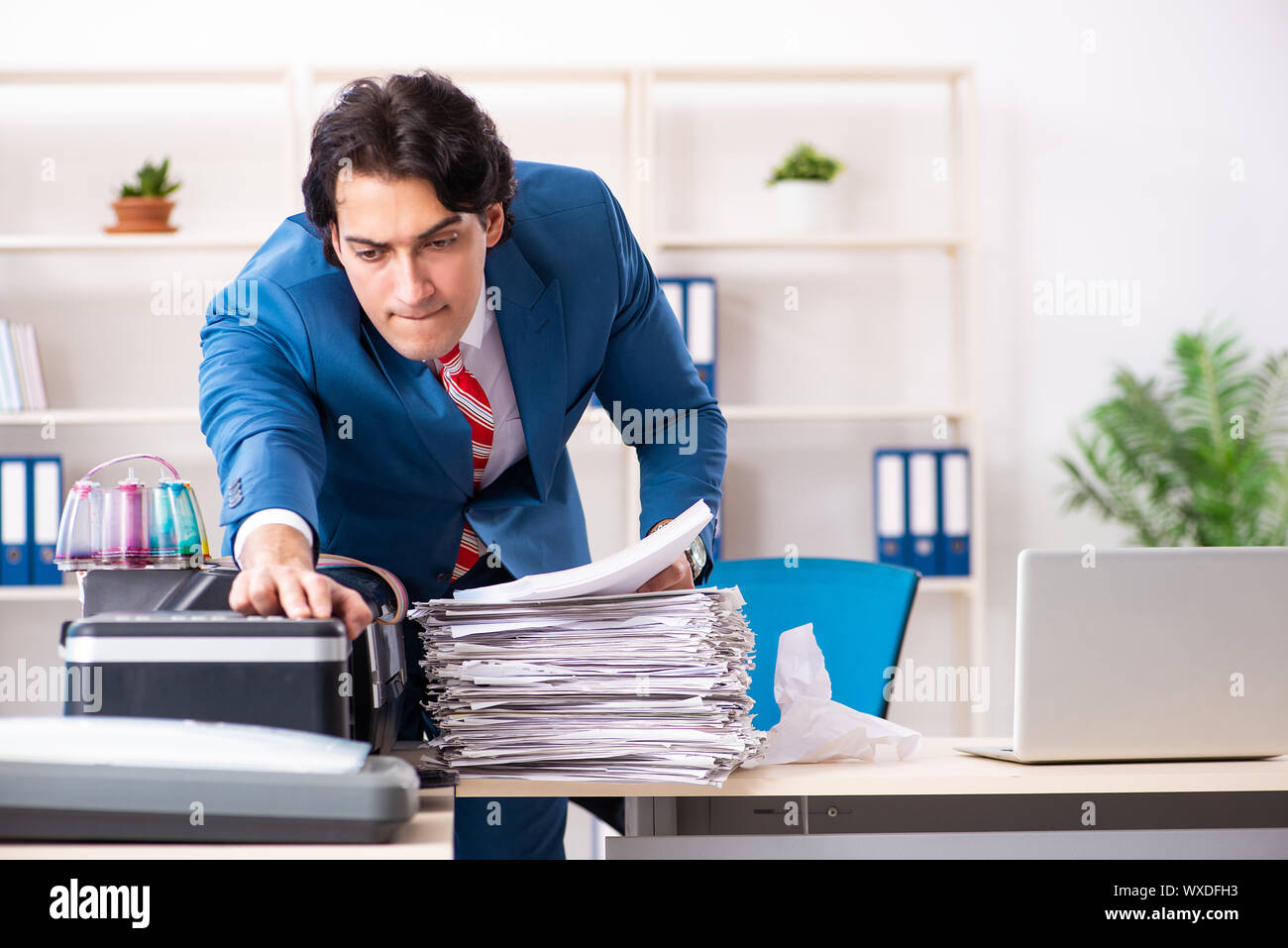 Young employee making copies at copying machine Stock Photo - Alamy