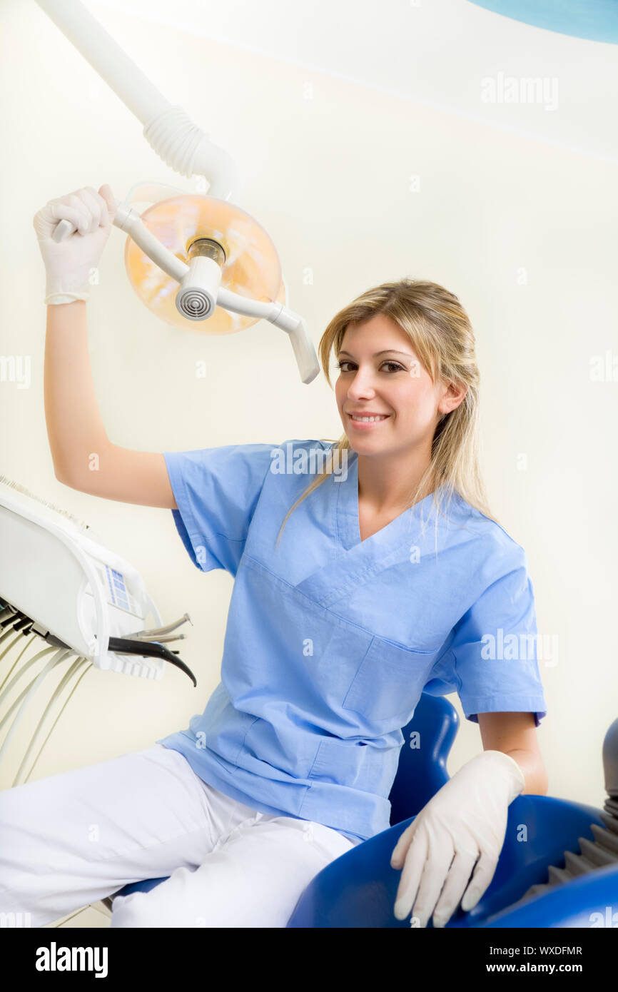 dental assistant smiling and adjusting the lamp Stock Photo - Alamy