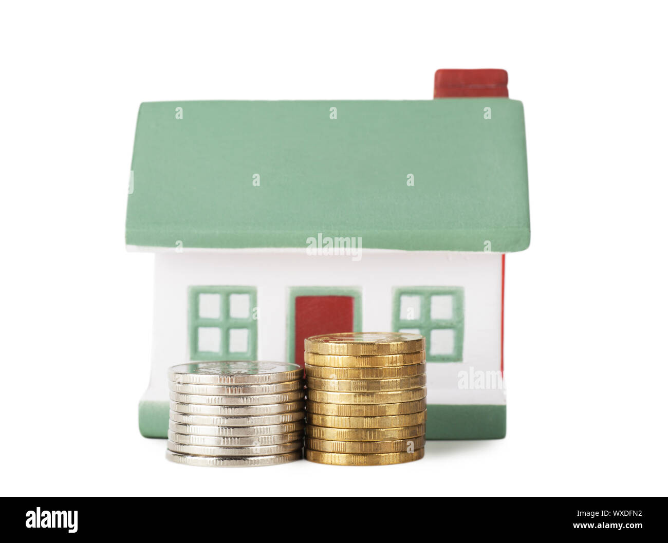 Little house toy and two stacks of coins isolated over white background ...