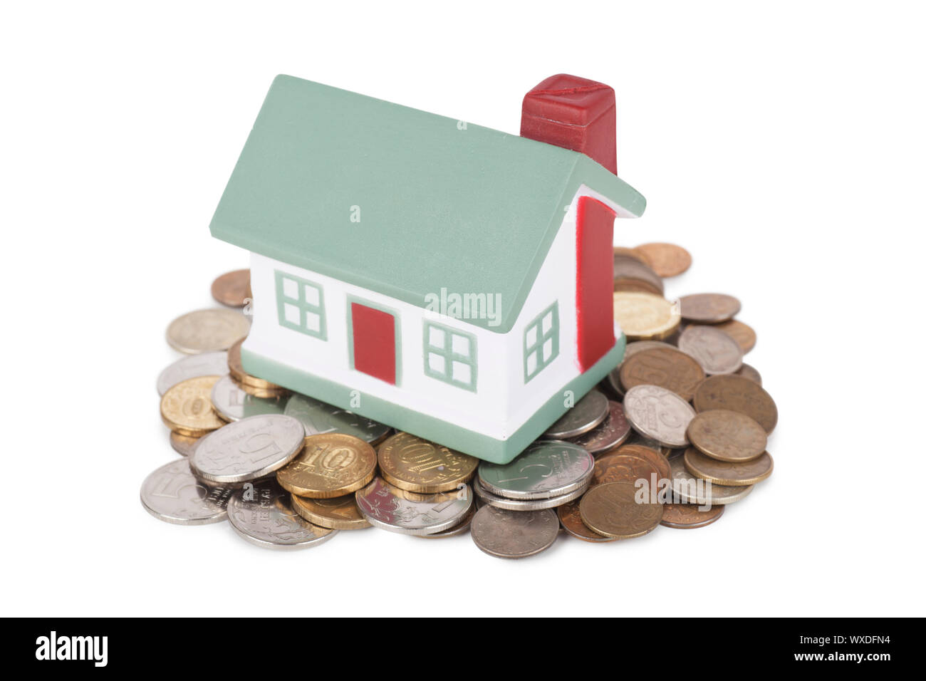 Little house toy on a heap of coins isolated over white background ...