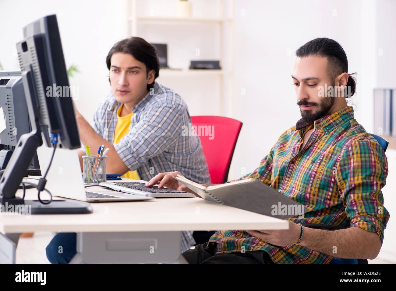 Two it specialists working in the office Stock Photo - Alamy