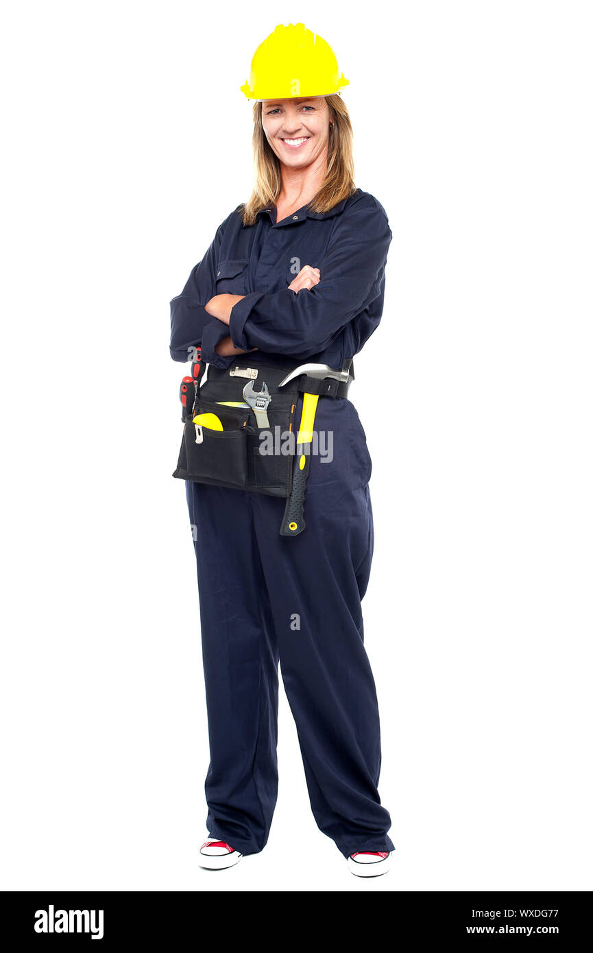 Full length portrait of smiling female worker wearing safety helmet and ...