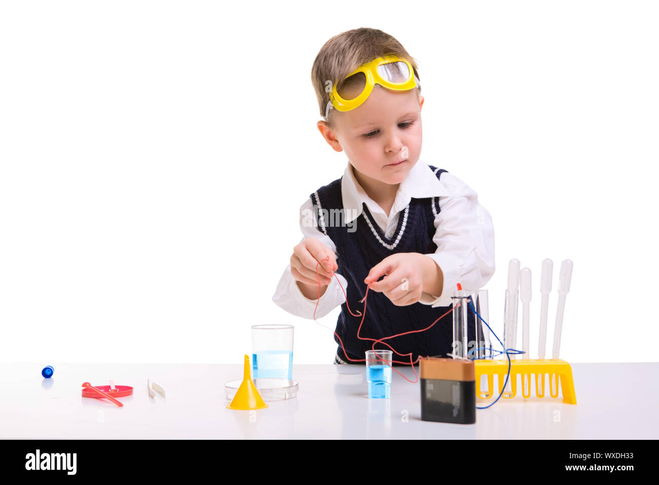 Young boy performing experiments with battery and small lamp Stock ...