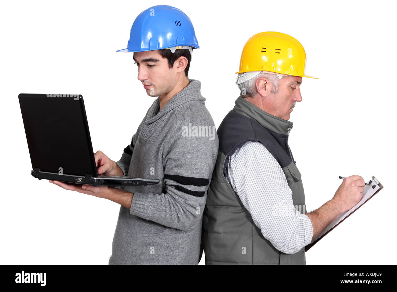 Builder and apprentice with laptop and clipboard Stock Photo - Alamy