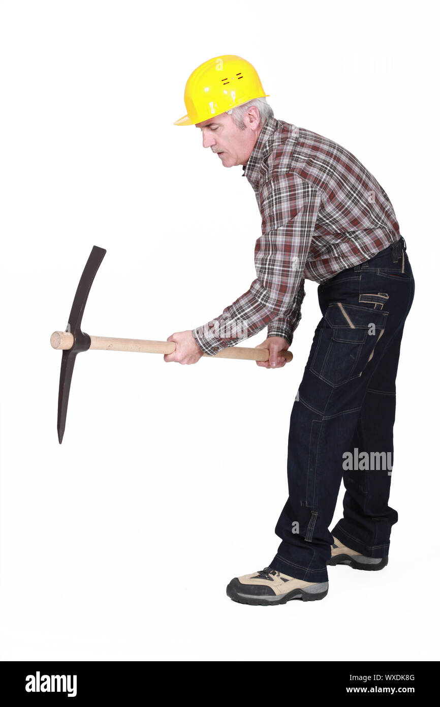 A mature construction worker using a pickaxe Stock Photo - Alamy