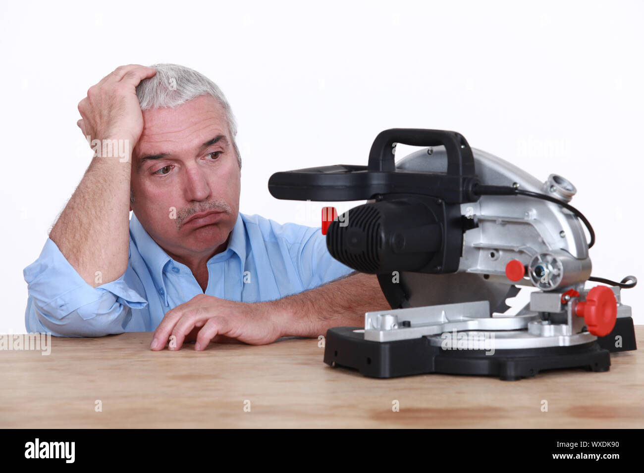 Man with circular saw looking fed-up Stock Photo - Alamy