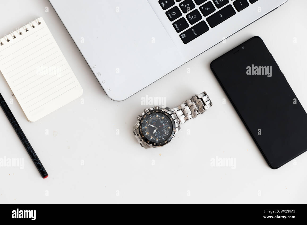 White office desk with laptop watch key office plant mobile phone Stock ...