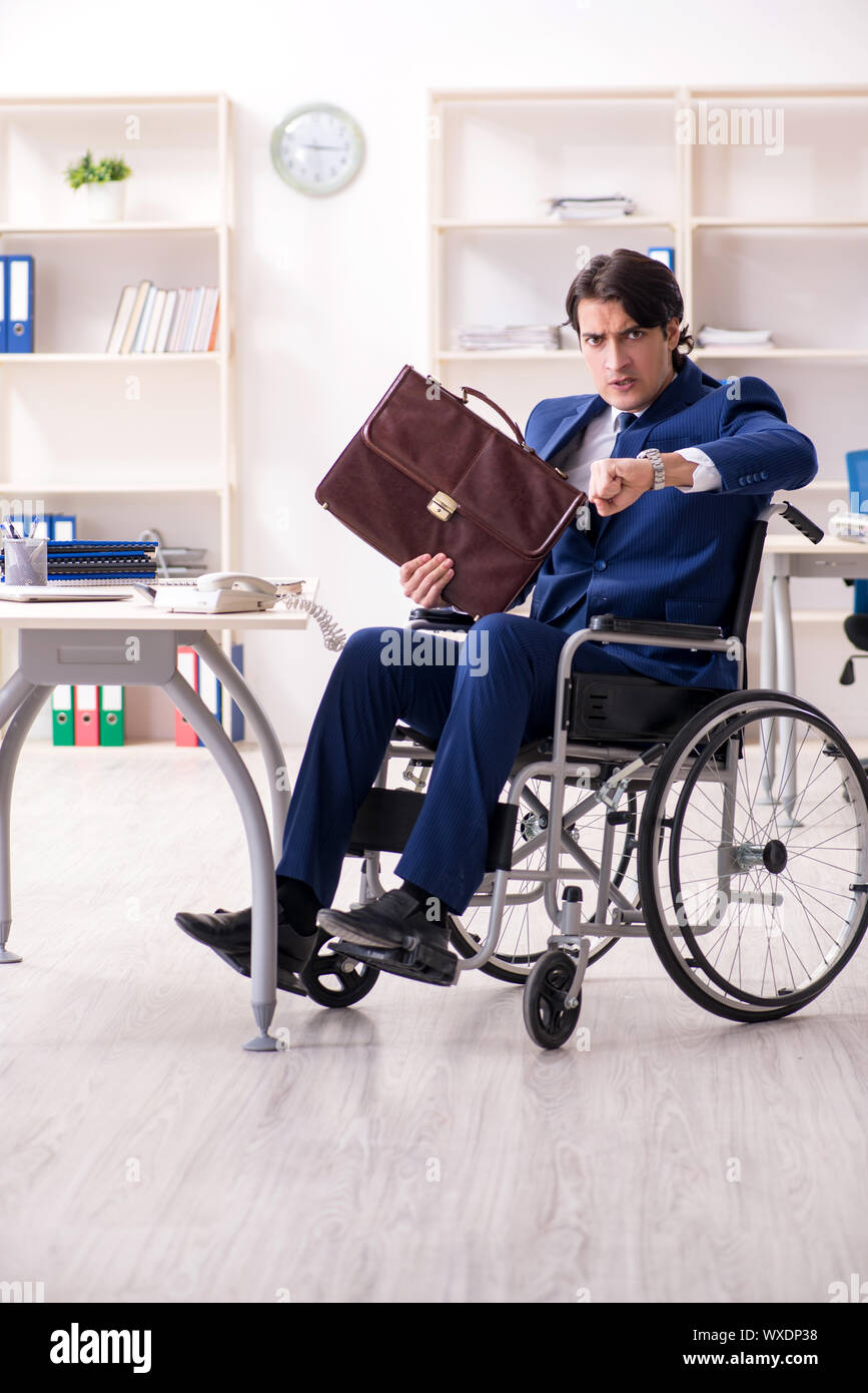 Young male employee in wheelchair working in the office Stock Photo - Alamy
