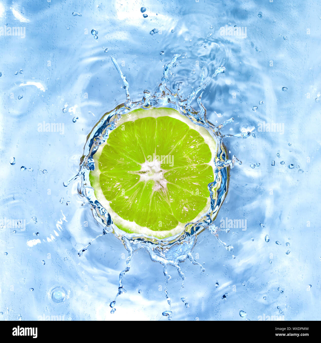 Fresh lime dropped into water with bubbles isolated on white Stock ...