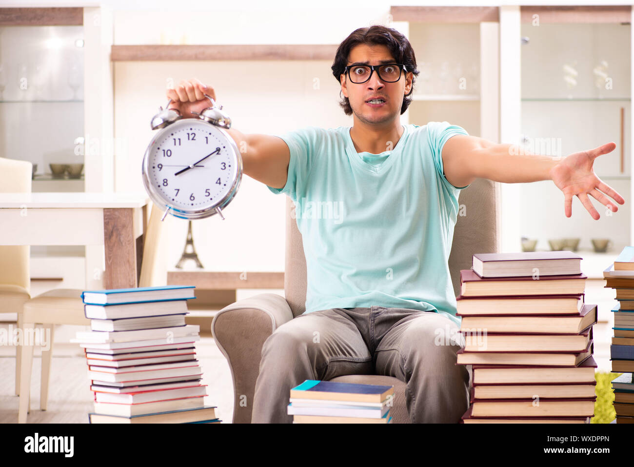 Male student with many books at home Stock Photo - Alamy