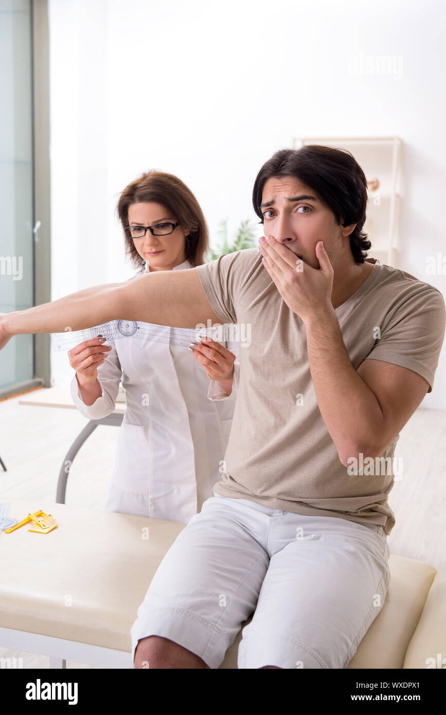 Female doctor checking patient's joint flexibility with goniometer ...