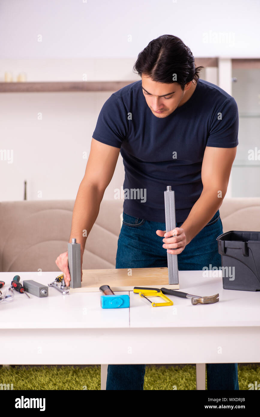 Young man repairing furniture at home Stock Photo - Alamy