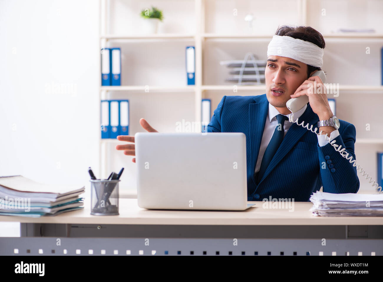 Head injured male employee working in the office Stock Photo - Alamy
