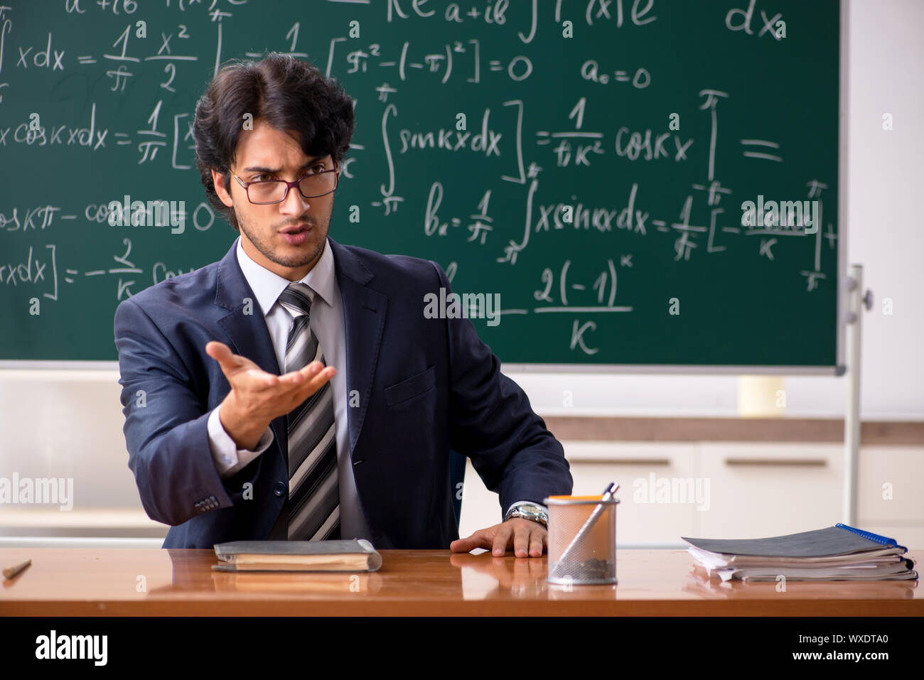 Young male math teacher in classroom Stock Photo - Alamy
