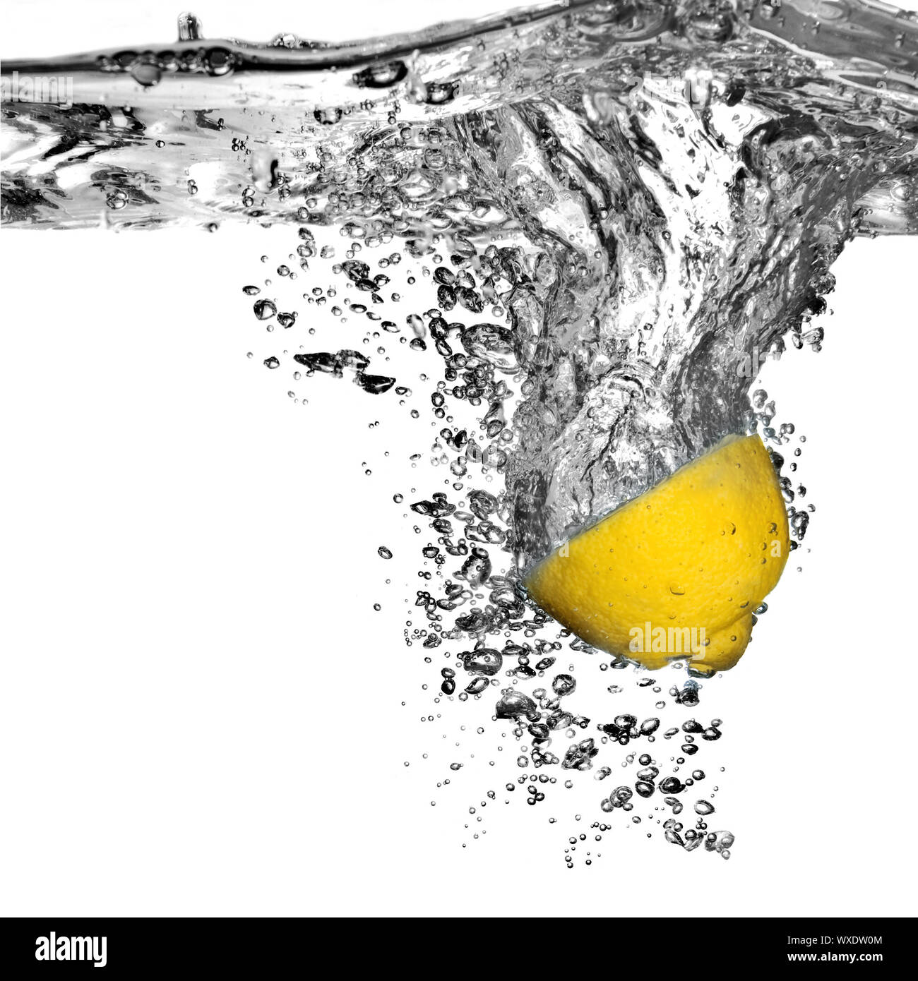 Fresh lemon dropped into water with bubbles isolated on white Stock ...