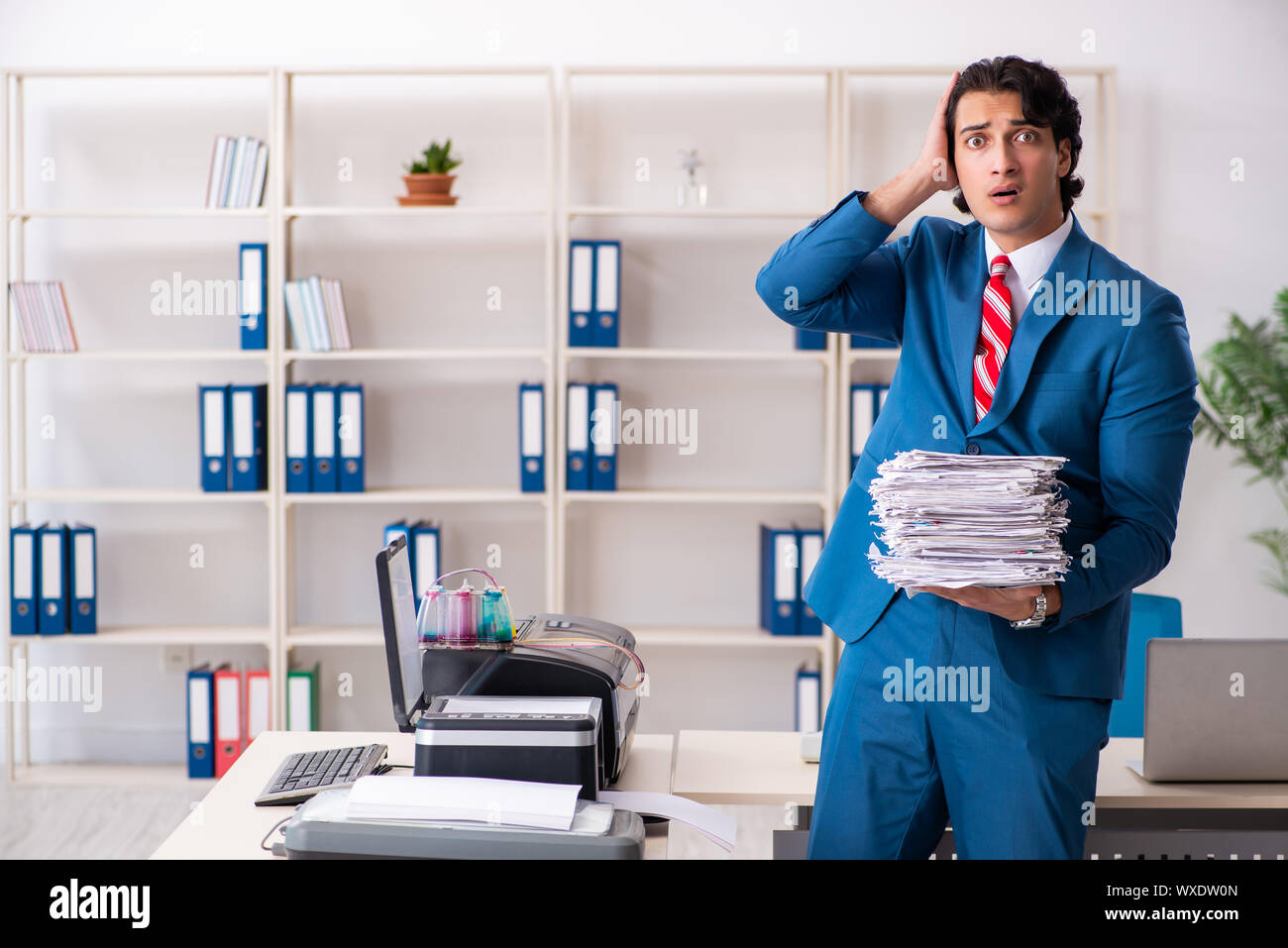 Young employee making copies at copying machine Stock Photo - Alamy