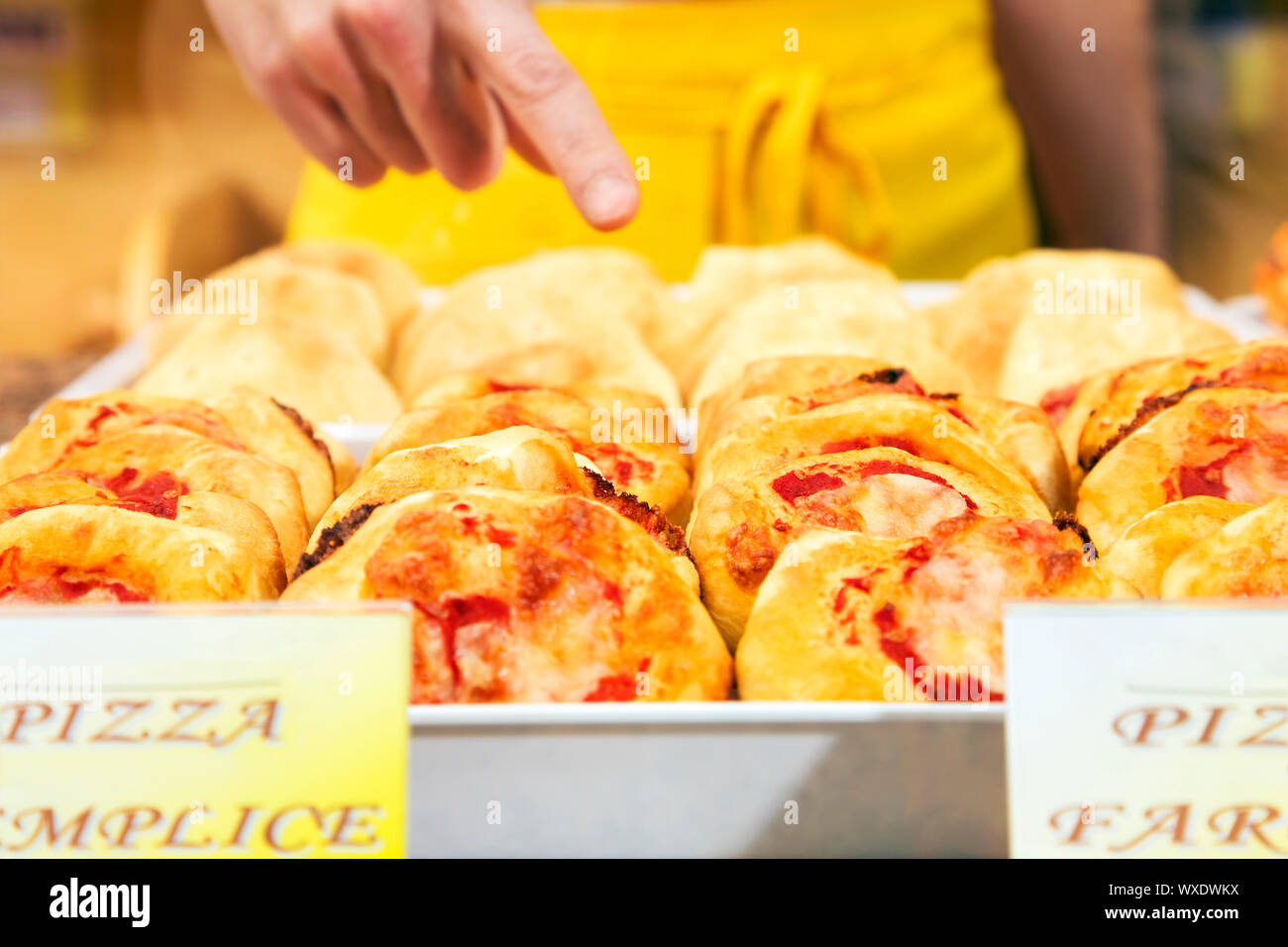 sales clerk in a supermarket pointing a slice of pizza Stock Photo - Alamy