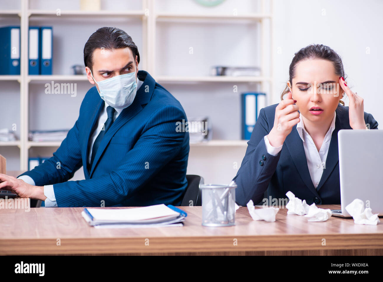 Two employees suffering at workplace Stock Photo - Alamy