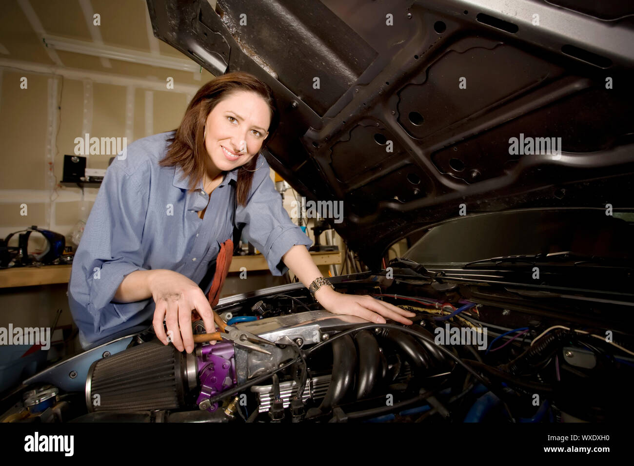 Female Hispanic mechanic working on a car engine Stock Photo - Alamy