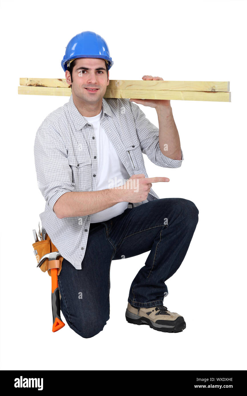 Builder carrying wood on shoulder Stock Photo - Alamy