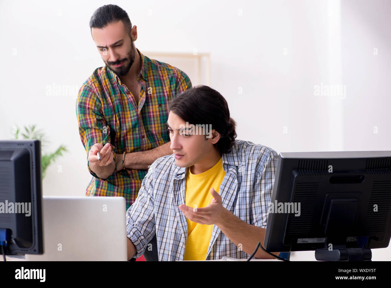 Two it specialists working in the office Stock Photo - Alamy