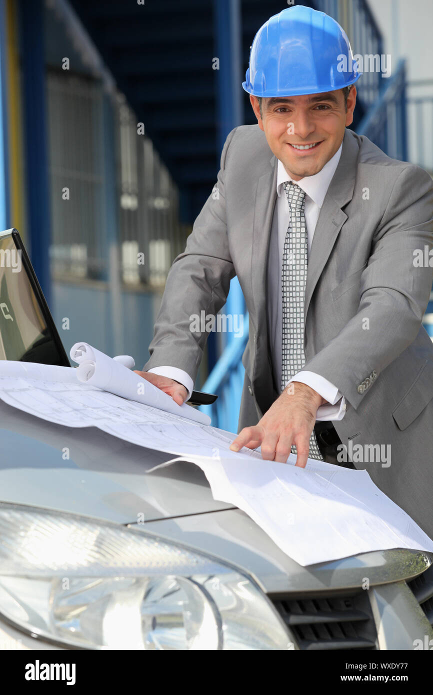 Engineer with architectural plans Stock Photo - Alamy