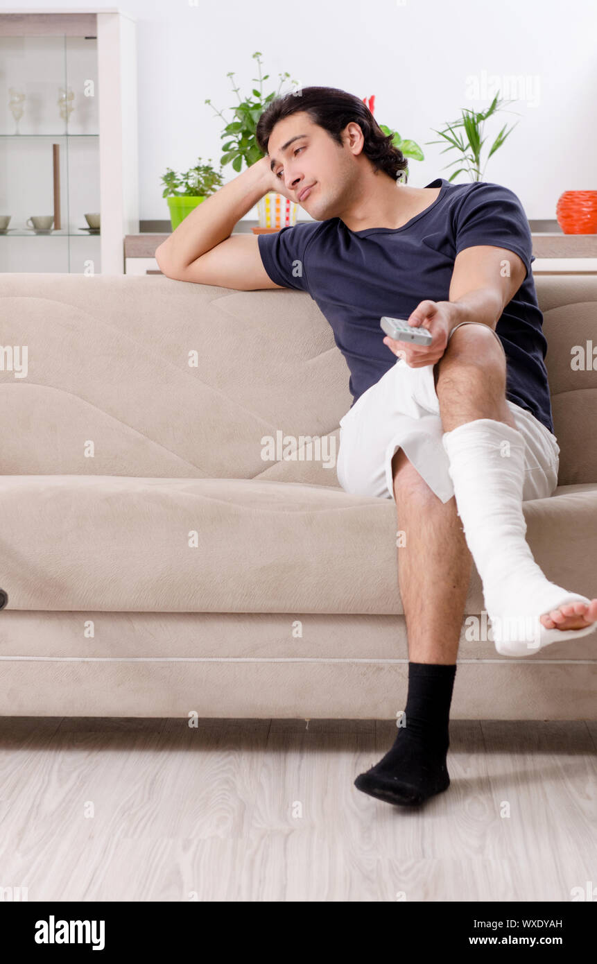 Leg injured young man suffering at home Stock Photo - Alamy