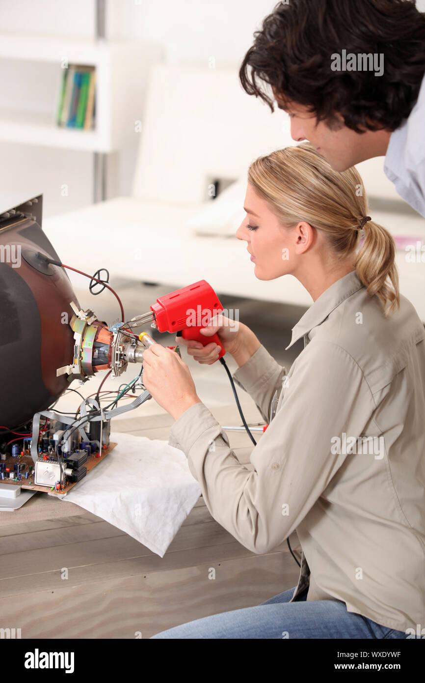 Woman fixing a television Stock Photo - Alamy