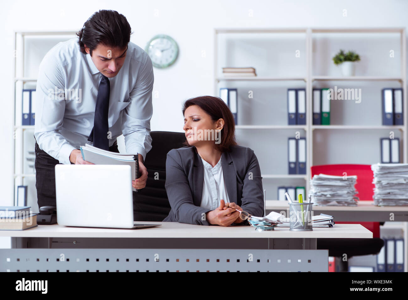 Old female boss and young male employee in the office Stock Photo - Alamy