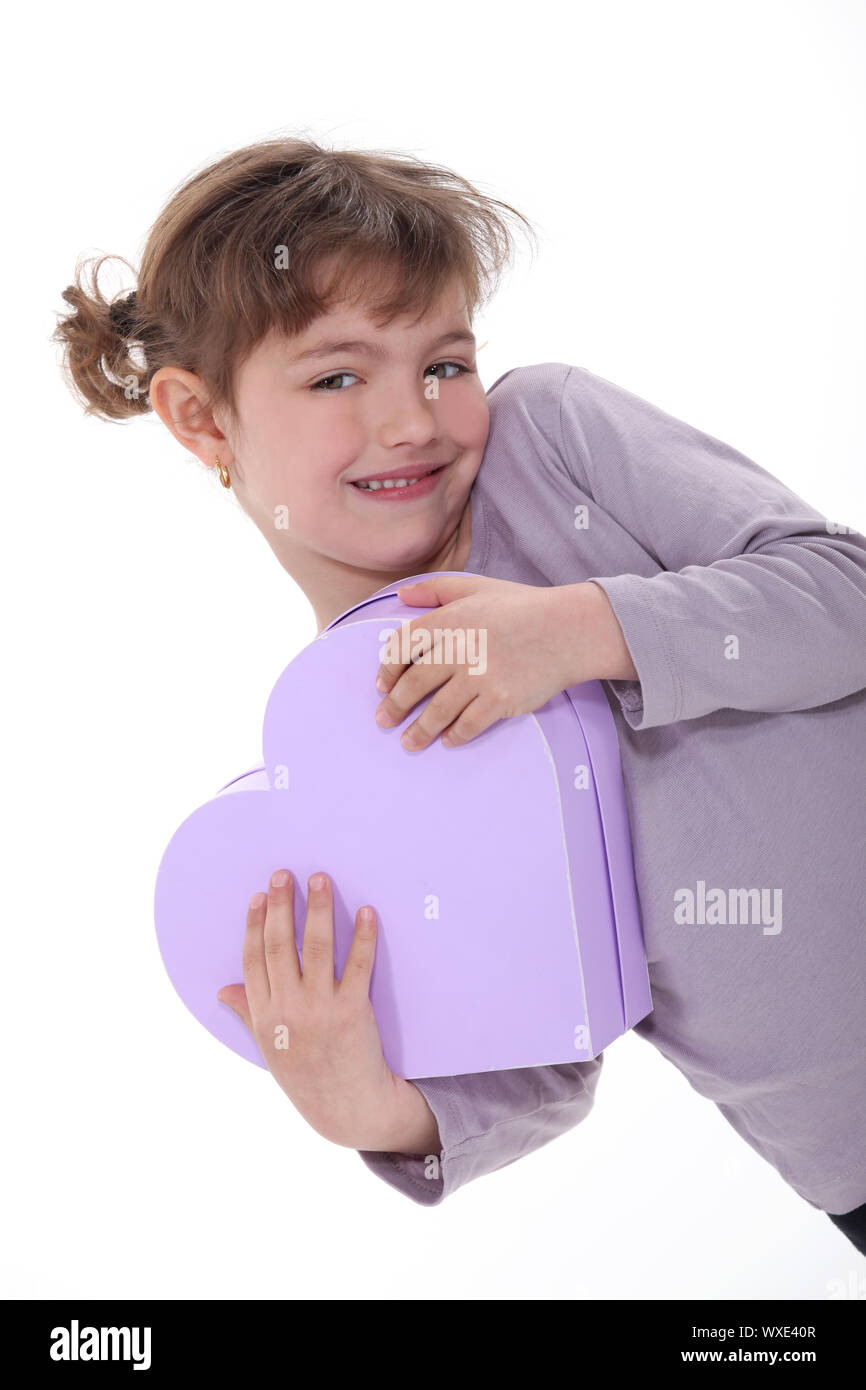 Adorable girl hugging a heart-shaped box Stock Photo - Alamy