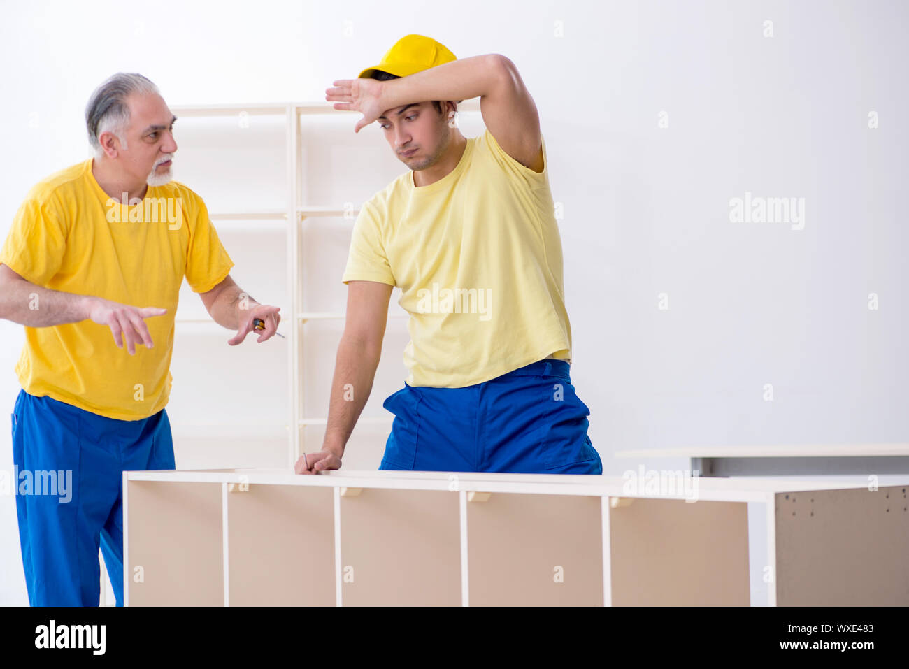 Two contractors carpenters working indoors Stock Photo - Alamy