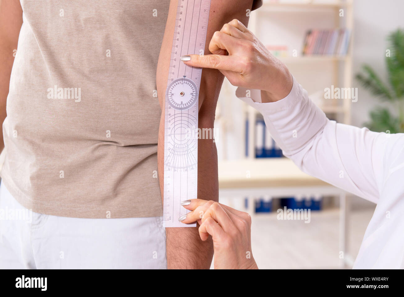 Female doctor checking patient's joint flexibility with goniometer ...