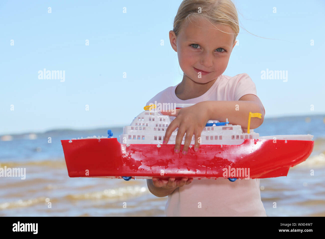 Girl playing with toy boat Stock Photo - Alamy