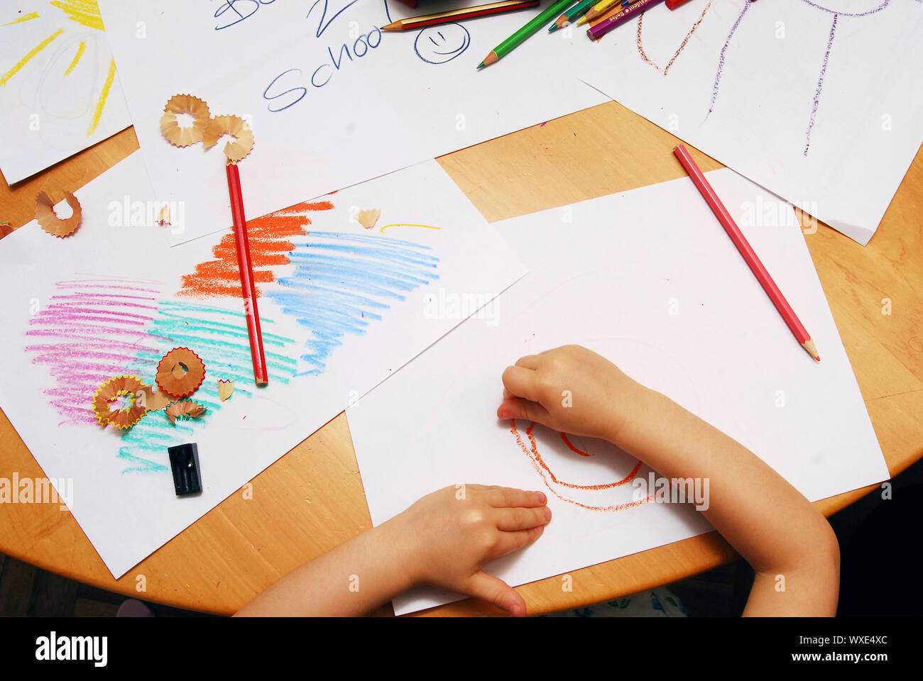 Little hands drawing between school supplies Stock Photo - Alamy
