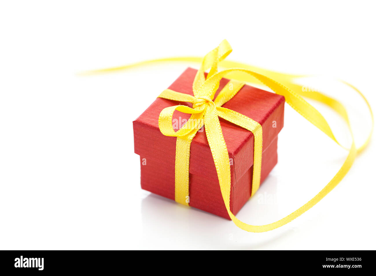 red gift box with a yellow ribbon isolated on white Stock Photo - Alamy