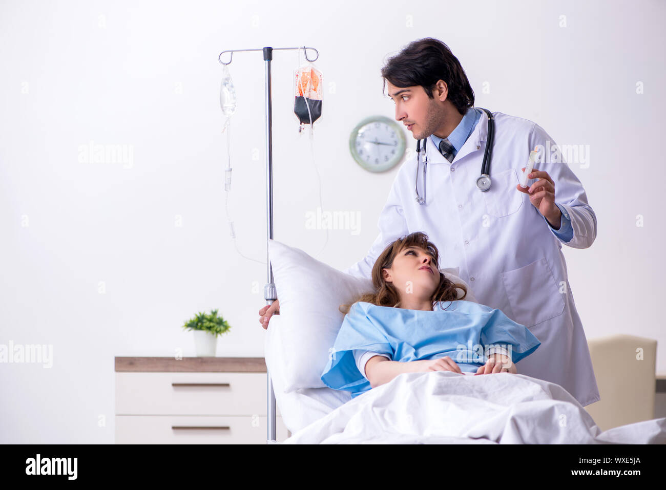 Male doctor visiting female patient in ward Stock Photo - Alamy