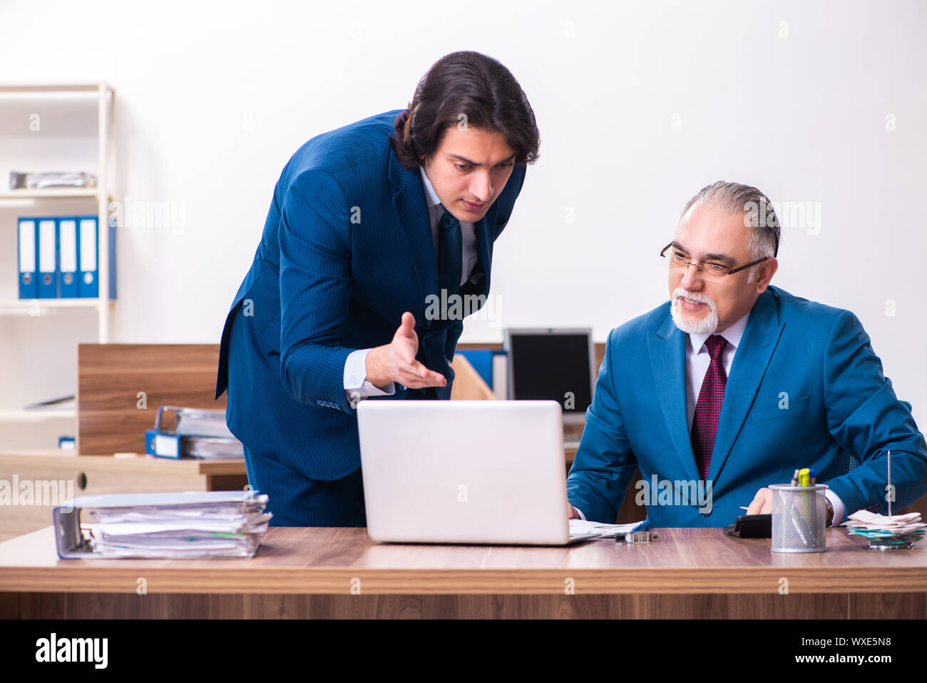 Young and old employees working together in the office Stock Photo - Alamy