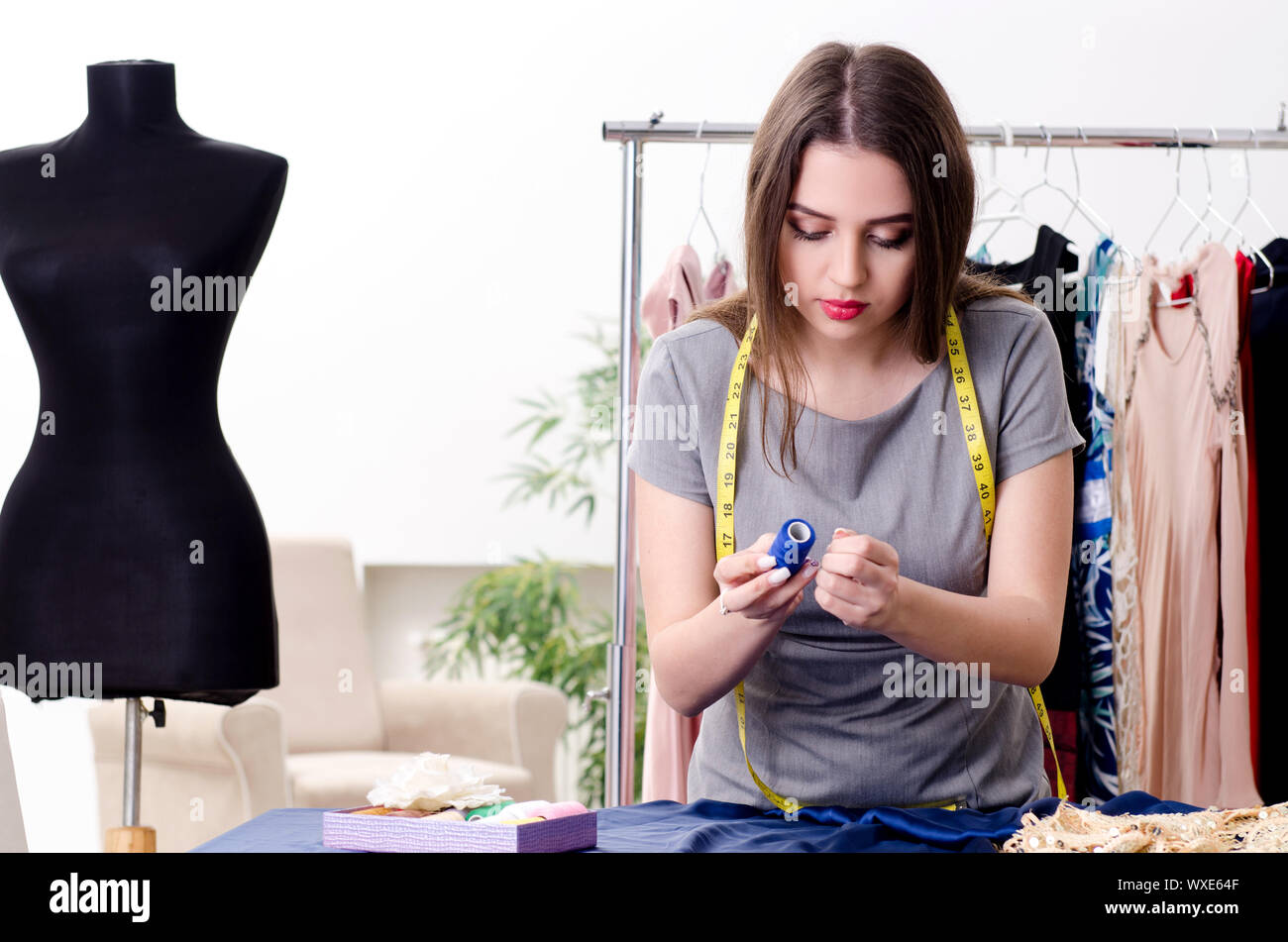 Young beautiful female tailor taking measurements Stock Photo - Alamy
