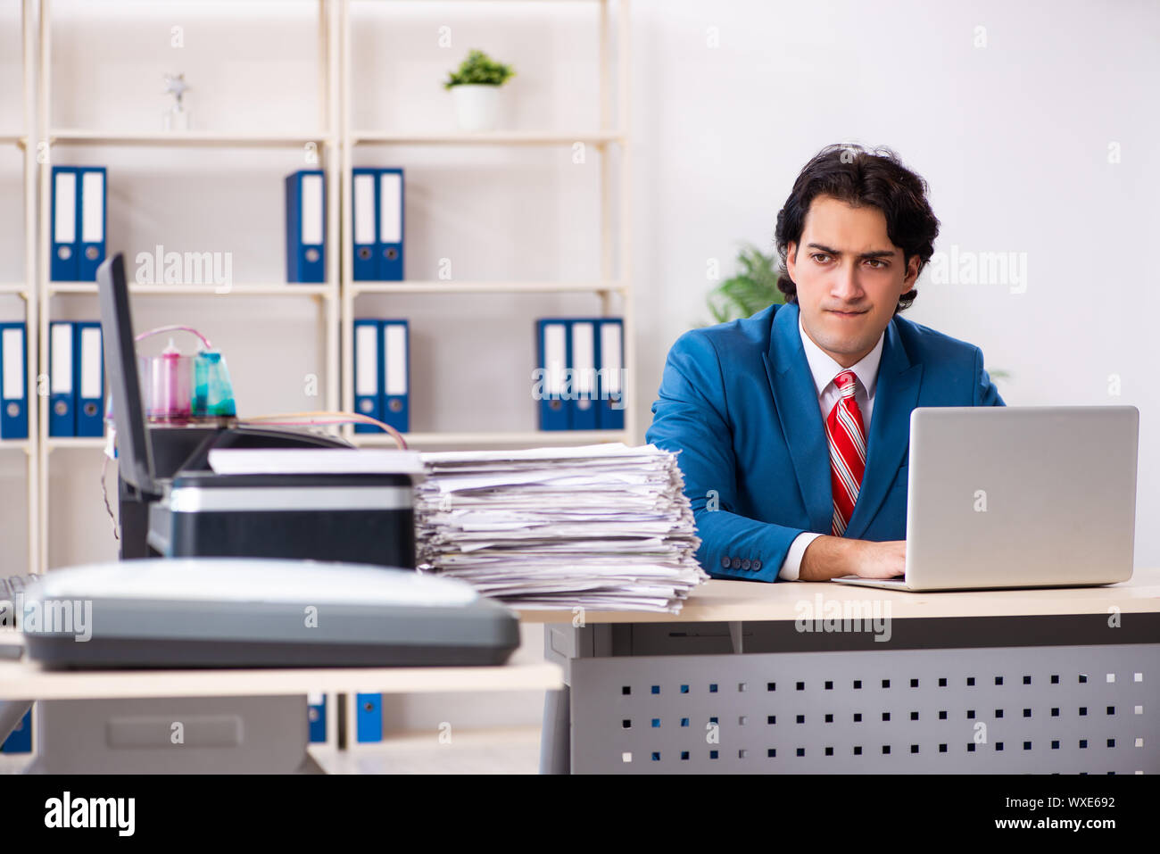 Young employee making copies at copying machine Stock Photo - Alamy