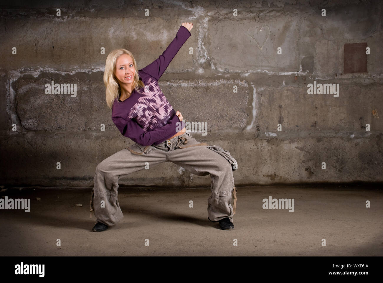 Beautiful hip hop girl dancing over grey brick wall Stock Photo - Alamy