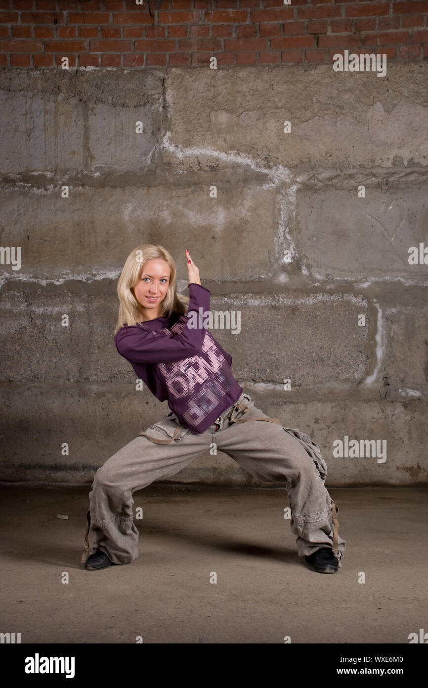 Beautiful hip hop girl dancing over grey brick wall Stock Photo - Alamy