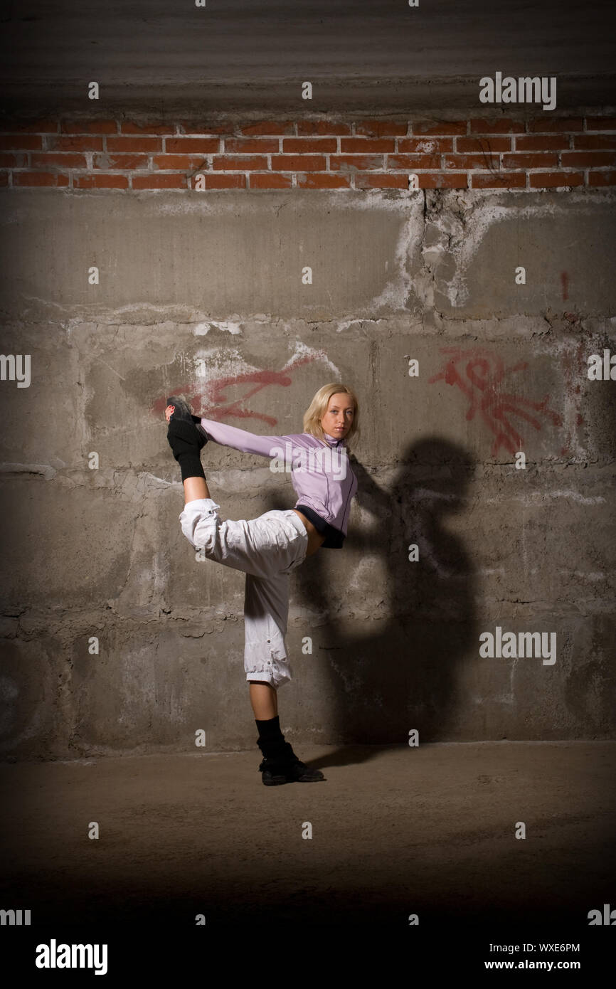 Beautiful hip hop girl dancing over grey brick wall Stock Photo - Alamy